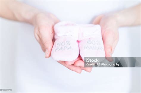 손에 아기 부츠를 가진 젊은 임산부 50 아빠 50 엄마 성별 공개 Gender Reveal Party에 대한 스톡 사진 및