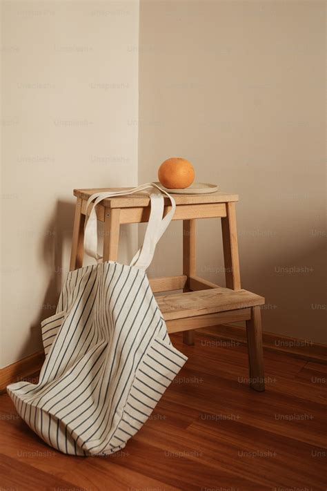 나무 의자 위에 앉아 있는 오렌지 사진 Unsplash의 미니멀리즘 이미지