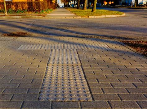 Textured Bumpy Section Of Concrete Sidewalk Nearing Street Intersection