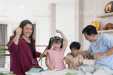 집에서 함께 책을 읽는 행복한 아시아 가족 웃는 부모와 십대 딸과 아들이 함께 시간을 보내고 있다 40 44세에 대한 스톡 사진