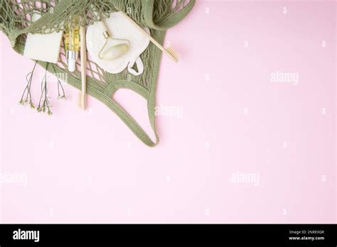 Cosmetic Products And Hygiene Items In A Green String Bag On A Pink