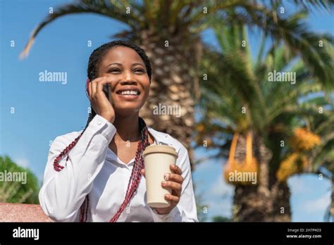 Smiling African American Woman Talking With Mobile With A Take Away