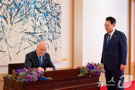 방명록 작성하는 럭슨 뉴질랜드 총리 바라보는 윤석열 대통령 뉴스1