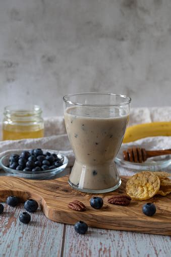 비건 칵테일 한 잔 또는 올리브 나무 보드에 바나나 블루 베리 꿀을 곁들인 귀리 우유로 만든 매끄러운 0명에 대한 스톡 사진 및 기타 이미지 Istock