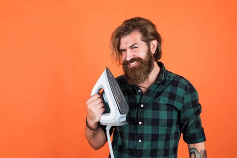 A escolha inteligente jovem maduro marido passando roupas em casa quente e evaporação