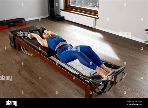 The Instructor Does Exercises On The Reformer A Beautiful Girl Trains On The Modern Reformer
