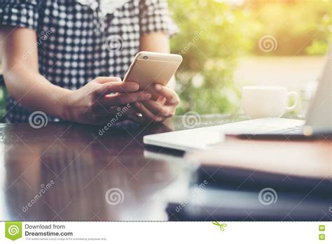 Руки женщины битника используя Smartphone на кофейне с нежностью