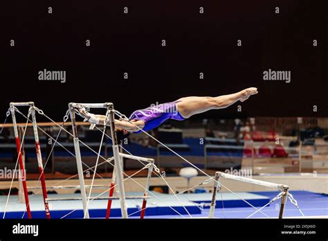 Woman Gymnast Exercise On Uneven Bars Gymnastics On Black Background