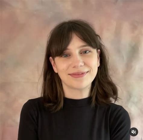 A Woman With Shoulder Length Hair Smiling At The Camera And Wearing A