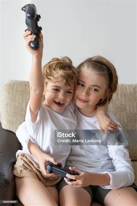 컨트롤러 콘솔로 비디오 게임을 하는 귀여운 아이들 취미 플레이스테이션 조이스틱을 즐기면서 감정을 표현하는 형제 자매 세로 10 11세에 대한 스톡 사진 및 기타 이미지