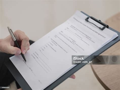 고객이 펜을 들고 서명하기 전에 주택 구매 계약서를 읽고 있습니다 주택 대출 계약 체결 새 집주인 주택 구입 20 24세에 대한