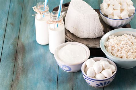 파란색 배경에 테이블에 맛 있는 건강 한 유제품 사 우 어 크림 코 티 지 치즈 모 짜 렐 라 치즈 버터 리 코타와 우유 한