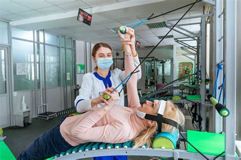 특수 재활 장치에 여성 환자와 함께 일하는 여성 의사 재활 학자 20 24세에 대한 스톡 사진 및 기타 이미지 20 24세