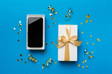 골드 리본과 스마트폰이 있는 기프트 박스를 컬러 배경 상단 보기로 오픈했습니다 빈 오픈 박스 포장 모형 디자인템플릿 브랜딩 모형 Brand Name Smart Phone에