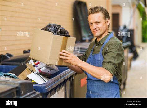 man sorting garbage before throwing it into trash can man possibly