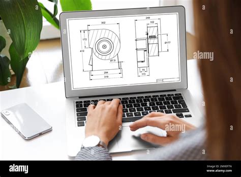 Female Engineer Working With Technical Drawing On Laptop Indoors Closeup Stock Photo Alamy