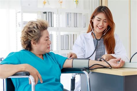 Premium Photo Smiling Doctor Examining Disabled Patient While Sitting