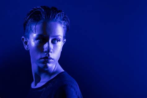 Ragazza Di Vista Laterale Che Posa Con La Luce Blu Foto Gratis