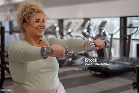 Smiling Chubby Size Woman Exercise With Dumbbell In Fitness Club Stock