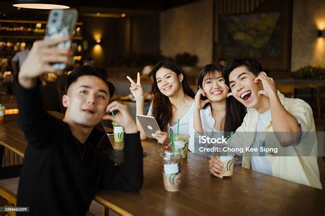 Group Of Attractive Asian Friends Are Taking Selfies While Hanging Out