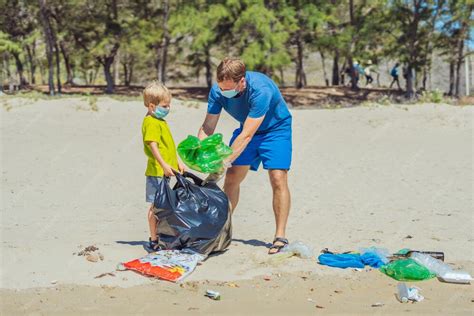 Premium Photo Volunteer Blue Face Mask Forest Sand Beach Son Helps Father Hold Black Bag For