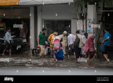 People Walk On A Waterlogged Streets After A Heavy Monsoon Rain In