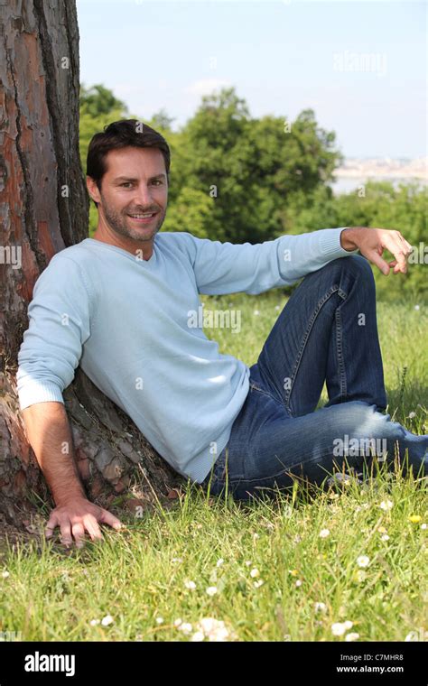 Man Sitting Under A Tree Stock Photo Alamy