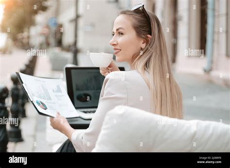 Business Woman Works On A Laptop While Sitting At A Table In An Outdoor