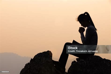 한 여성의 실루엣이 산에서 신에게 기도하고 있다 축복의 배경에서 종교에 대한 믿음과 하나님에 대한 믿음으로 기도하는 손 희망의 힘 또는 사랑과 헌신 기도하기에 대한 스톡