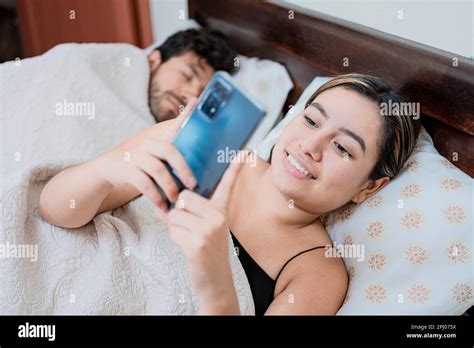 Unfaithful Wife With Phone While Her Husband Sleeps Unfaithful Woman