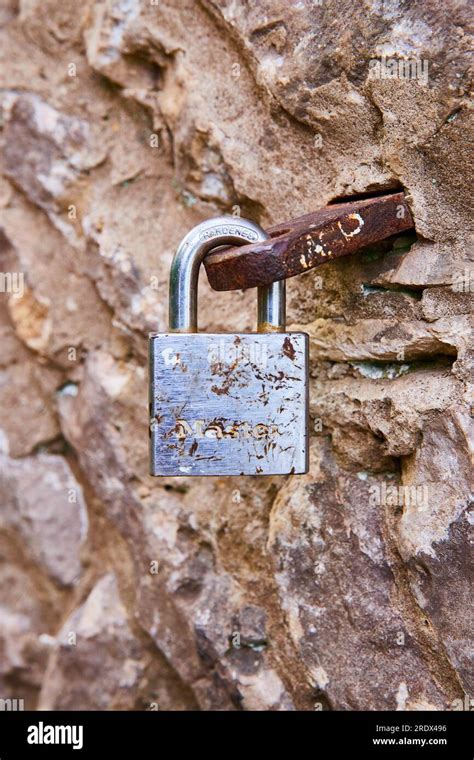 Tan Rock Wall Rusty Metal Loop Hook Rusting Closed Silver Metal Lock