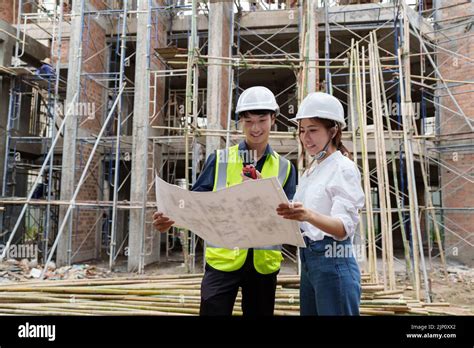 Structural Engineer And Architect Discussing And Working With Blueprints At The Outdoors