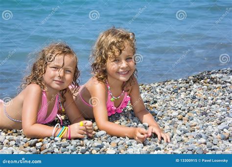 Zwei Kleine Mädchen Die Auf Steinigem Strand Liegen Lizenzfreies