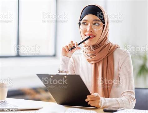 전통적인 종교 히잡을 입은 아름다운 웃는 무슬림 여성은 집에서 노트북으로 원격으로 일한다 기업 비즈니스에 대한 스톡 사진 및