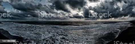 어두운 적운 구름이 있는 극적인 하늘과 해안에서 부서지는 파도가 치는 폭풍우 치는 바다가 있는 해변에서 펼쳐지는 무서운 날씨 일몰 파노라마 0명에 대한 스톡 사진 및 기타