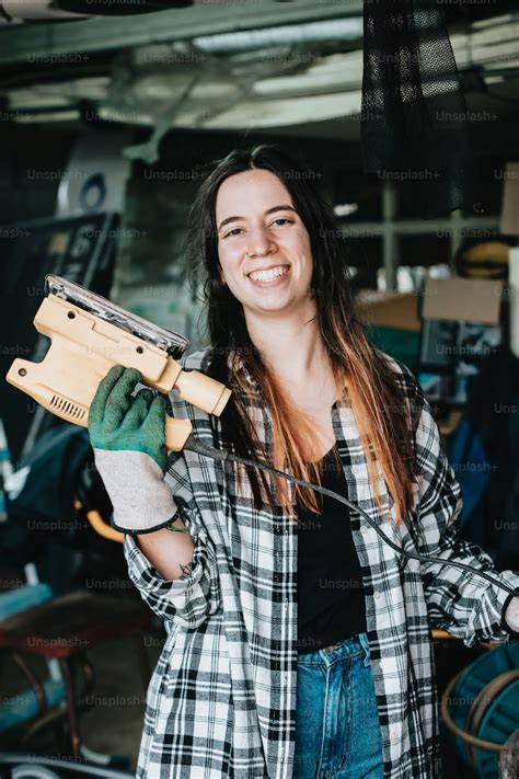 격자 무늬 셔츠와 녹색 장갑을 끼고 기관총을 들고 있는 여성 사진 Unsplash의 여성 이미지