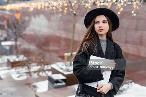 젊은 패션 여자 잡고 그녀의 잡지 도시 거리에 도보 둘러 검은 모자를 착용 하 고 카메라에 미소 공간에 복사 합니다 이미지 가을에 대한 스톡 사진 및 기타 이미지 Istock