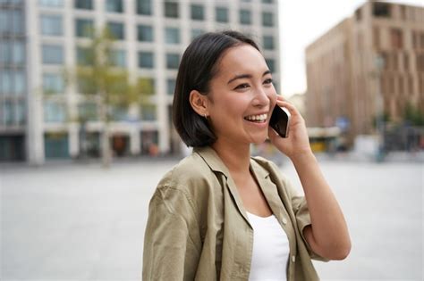 Premium Photo Modern Young Asian Girl Talks On Mobile Phone Uses