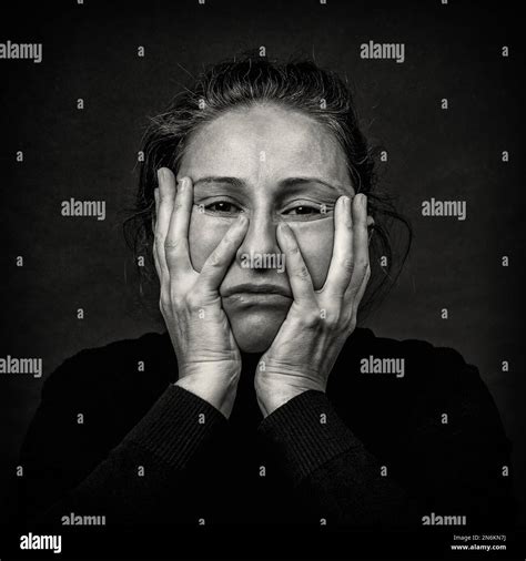 Conceptual Dark Portrait Of Old Depressed Woman Stretching The Skin Of