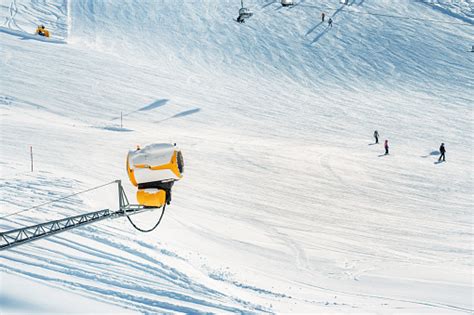 화창한 날에 힐랜드 알파인 산 겨울 리조트의 스키 리프트 로프 웨이 사람들이 스포츠 활동을 즐길 수있는 활강 슬로프의 파노라마 넓은 풍경보기 피스트 근처의 인공 눈 대포