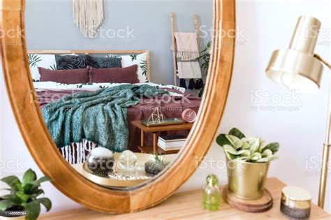 디자인 가구 세련 된 Macrame 나무 사다리와 우아한 액세서리와 침실의 현대적이 고 고급 스러운 인테리어 아름 다운 침대 시트 담요 및 베개 따뜻한 가정 장식 거울에서