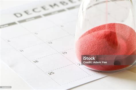 12 월 25 일을 표시하는 12 월 달력의 모래 시계 크리스마스까지 카운트 다운 시간의 흐름을 측정하는 모래 시계 전구를 통해