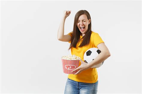 노란색 유니폼 축구공을 들고 좋아 라 여자 축구 팬 팝콘 상자 제스처 예를 말을 하 고 흰색 배경에 고립 스포츠 축구 치 어