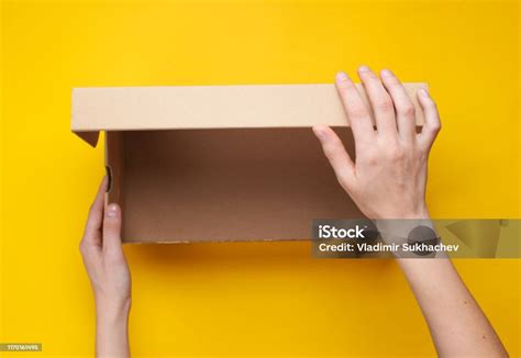 여성의 손은 노란색 배경에 빈 골판지 상자를 엽니 다 맨 위 보기 성탄절 선물에 대한 스톡 사진 및 기타 이미지 성탄절 선물
