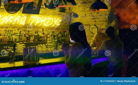 People At Counter Drink Cocktails In Bar With Neon Light Stock Footage