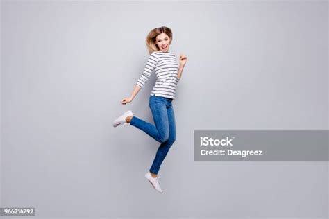 전체 길이 크기 몸 여자의 초상화 매력적인 재미 있고 만화 명랑 한 좋은 귀여운 제기 다리 카메라를 보고 점프 하는 줄무늬 옷에