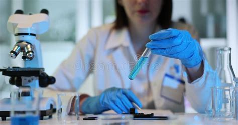 Scientist Chemist Holds Test Tube With Blue Liquid In Laboratory