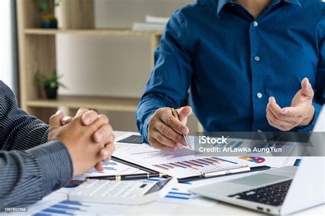 현대 컴퓨터 노트북나무 테이블에서 이야기하는 동안 회전 그래프를 가리키는 펜을 들고 있는 두 명의 사업가의 클로즈업 비즈니스 팀 분석 개념 및 전략의 클로즈업 2명에 대한