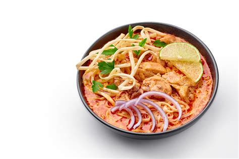 카오 소이 가이 또는 태국 코코넛 카레 국수 수프 에 검은 그릇에 흰색 배경에 고립 카오 간이 국수 치킨 고기 붉은 고추