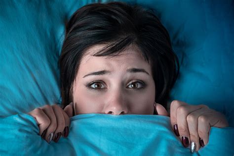 소녀는 침대에서 커버 아래에 그녀의 얼굴을 숨깁니다 공포 영화를 본 후 악몽 악몽에 대한 두려움 가리기에 대한 스톡 사진 및